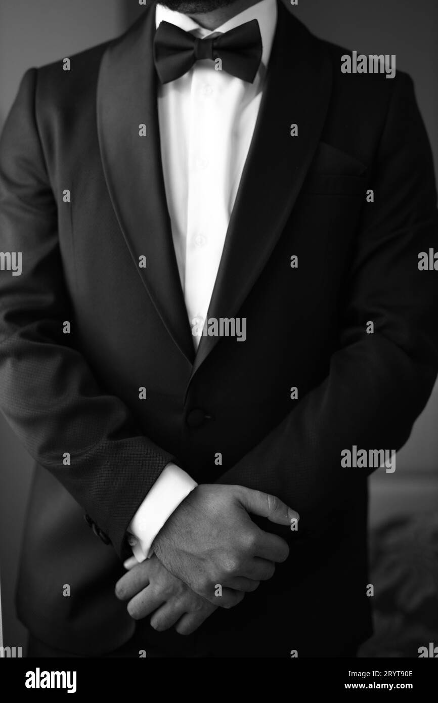 A young man pictured in formal attire, wearing a smart suit and bow tie ...