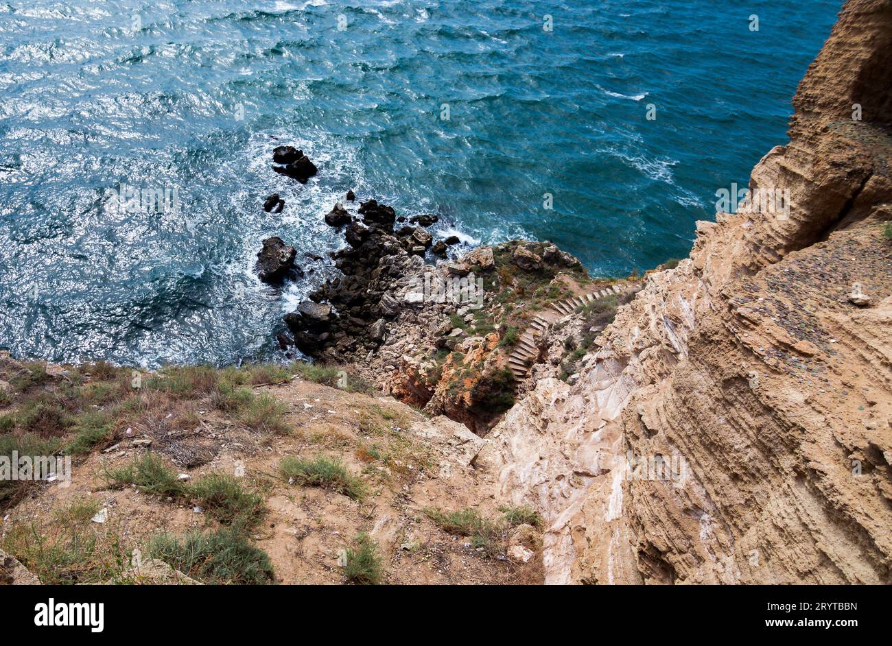 An expansive cliff face overlooking the breathtaking ocean, with waves ...
