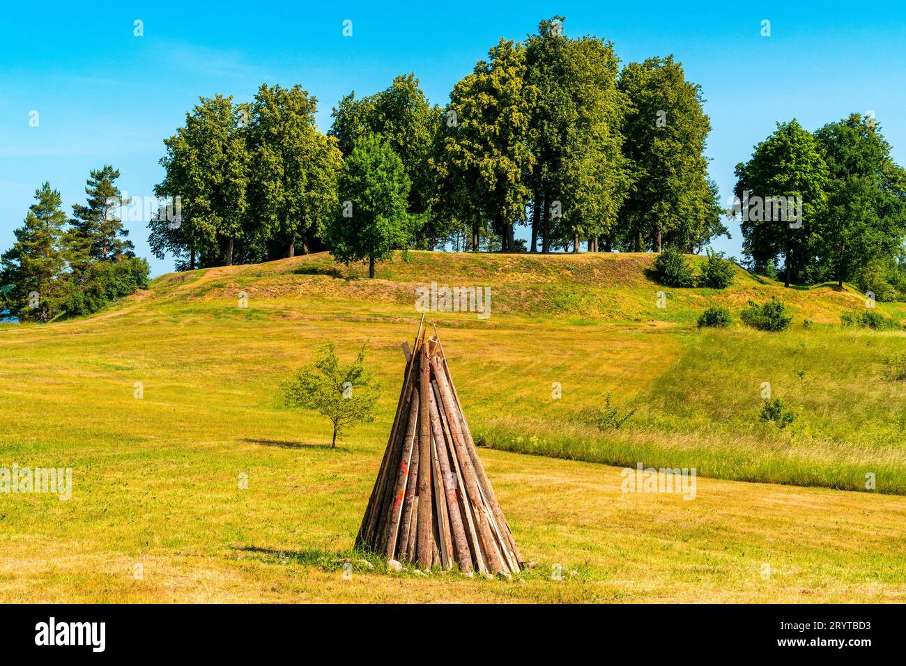 Firewood split and arranged for a bonfire outdoors with rural landscape ...