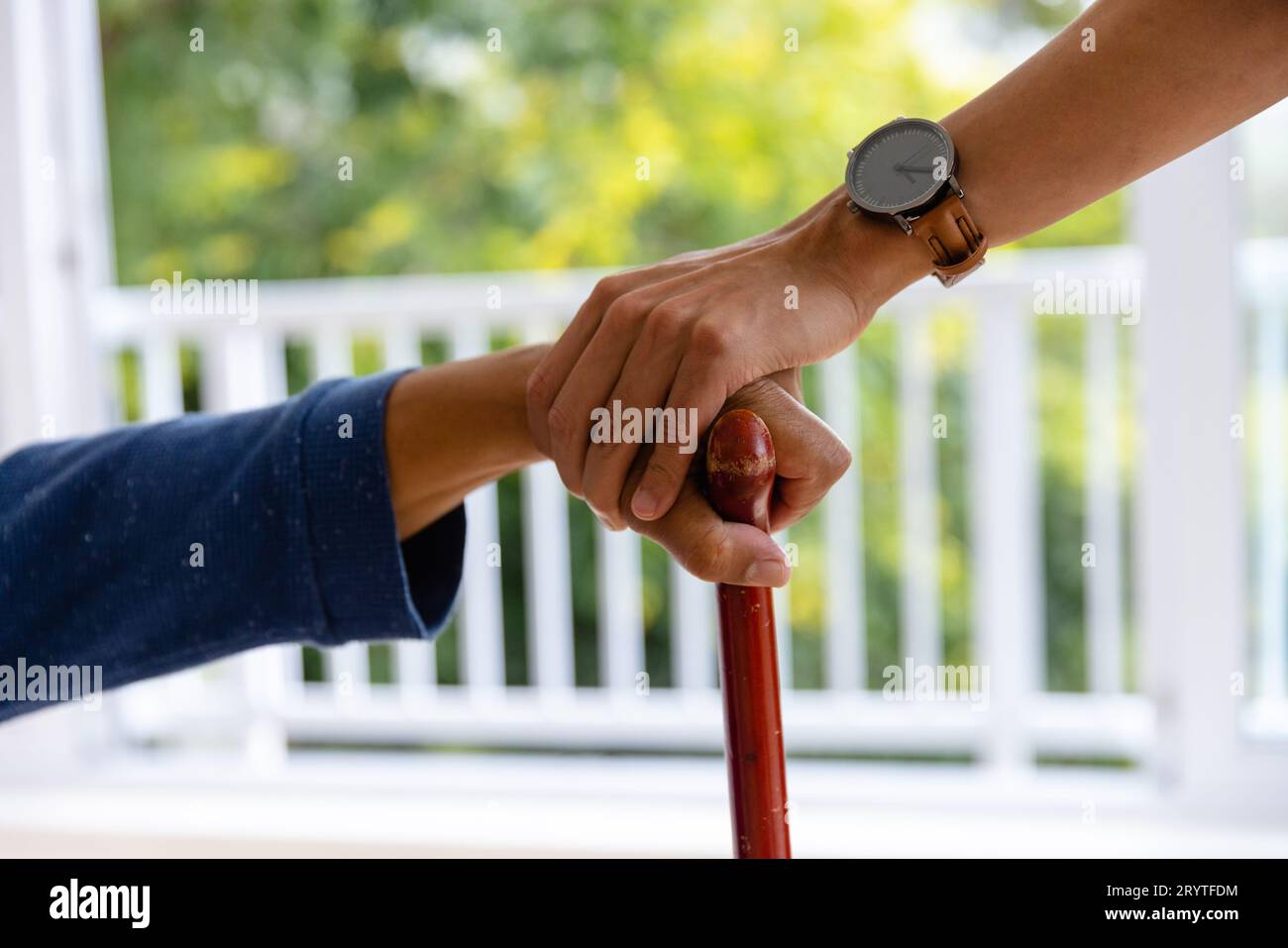 Hands of diverse male doctor and senior male patient holding walking ...