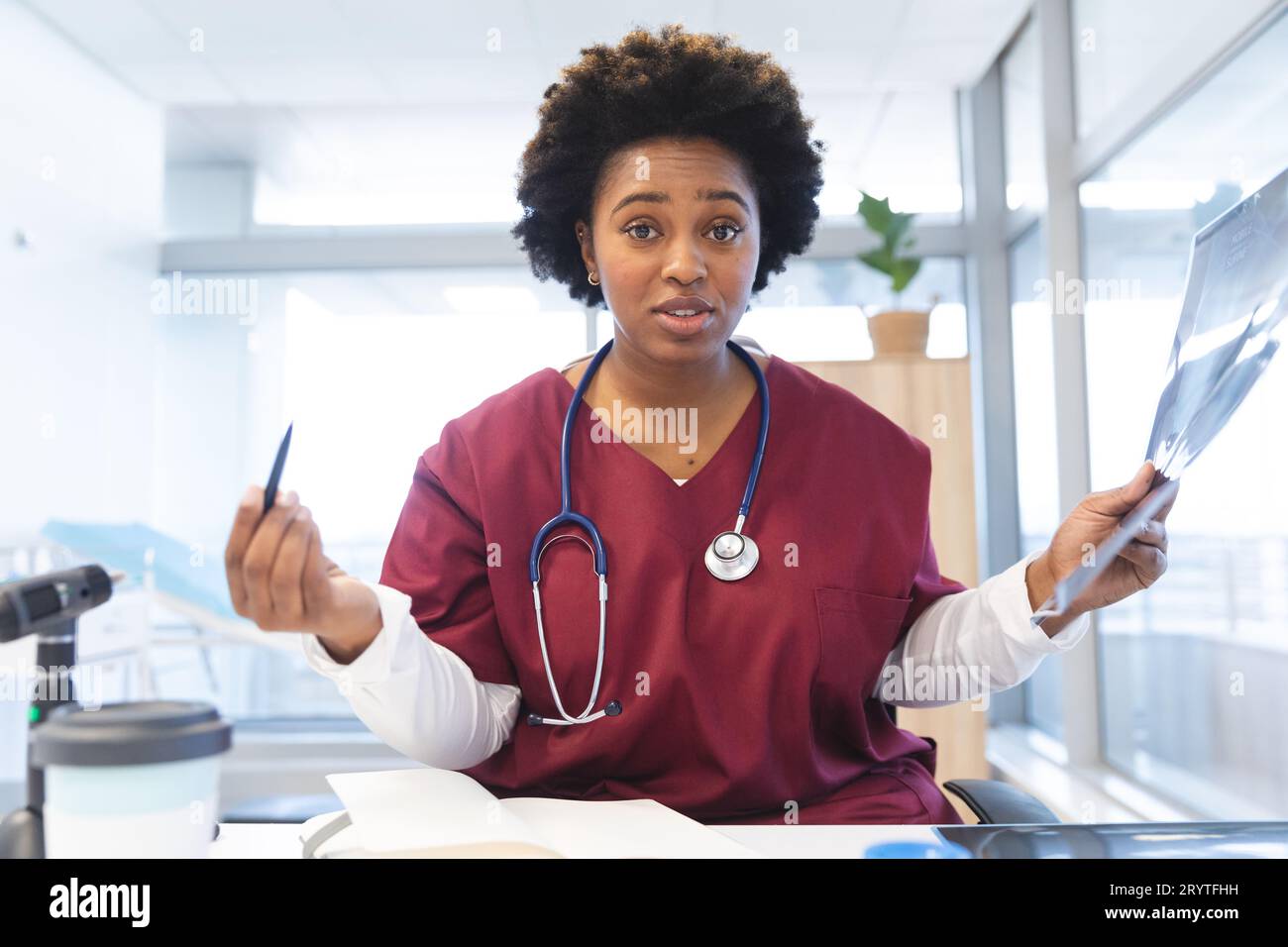 African american female doctor wearing scrubs and stethoscope, having ...