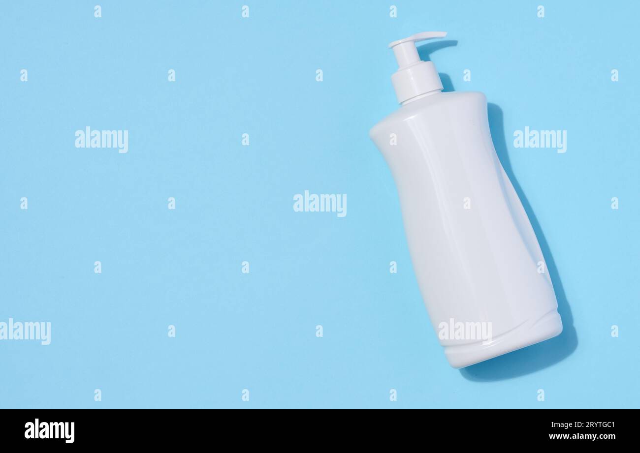 White plastic container with a pump for liquid products on a blue ...