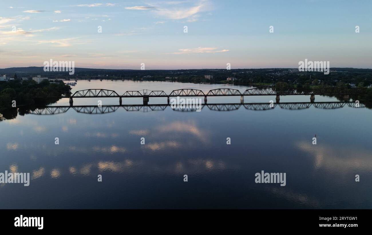 A long bridge spanning across a body of water, with its reflection ...