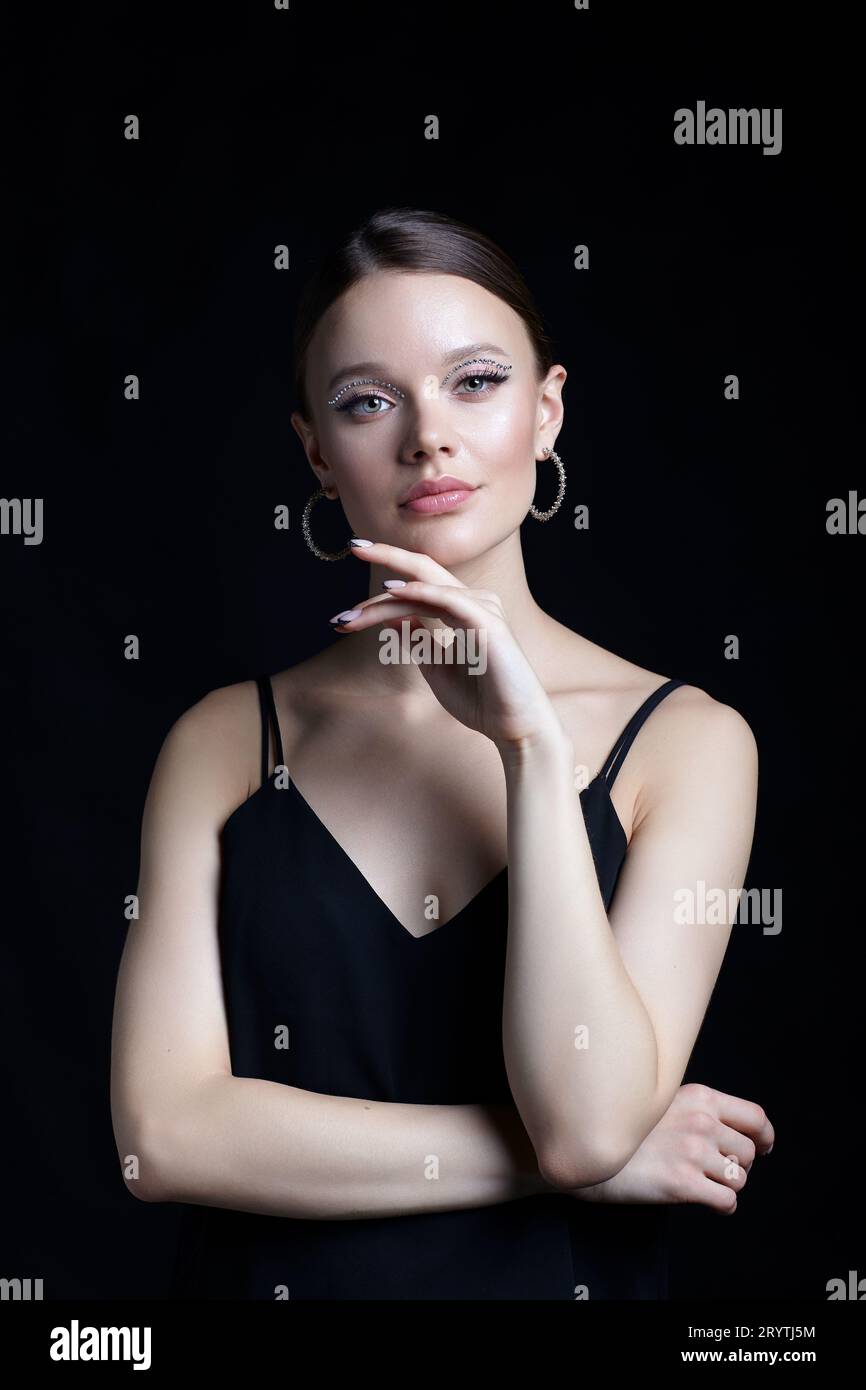 Female portrait with rhinestones makeup. Woman with earring in the form ...