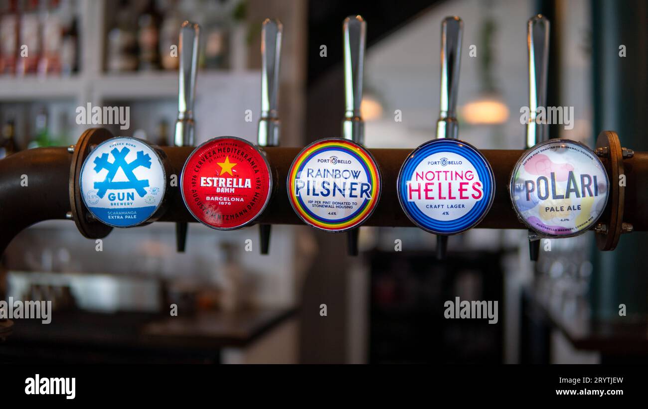 A row of five beer taps in a bar illuminated under a warm light Stock ...