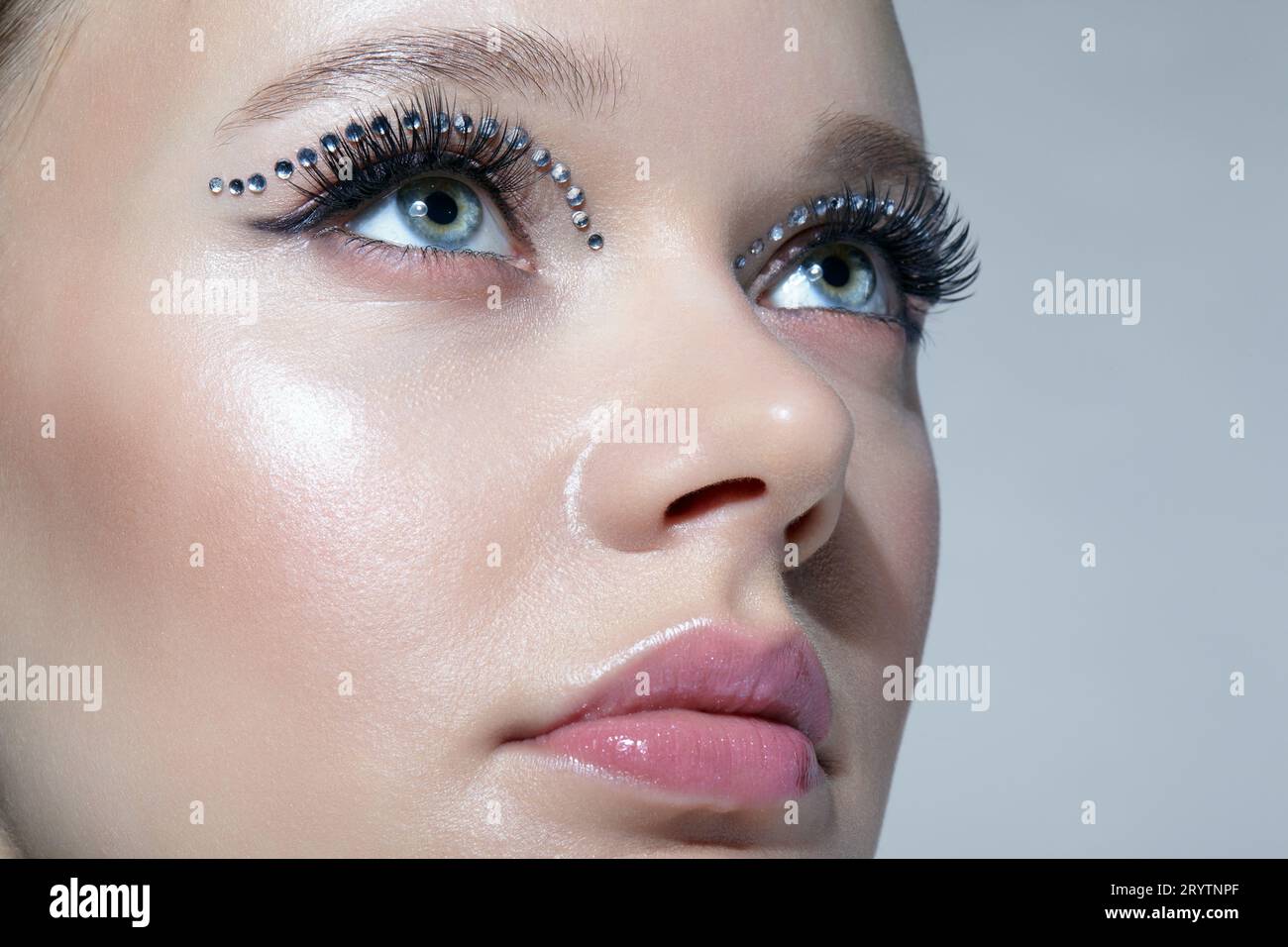 Closeup shot of human female face with unusual rhinestones makeup ...