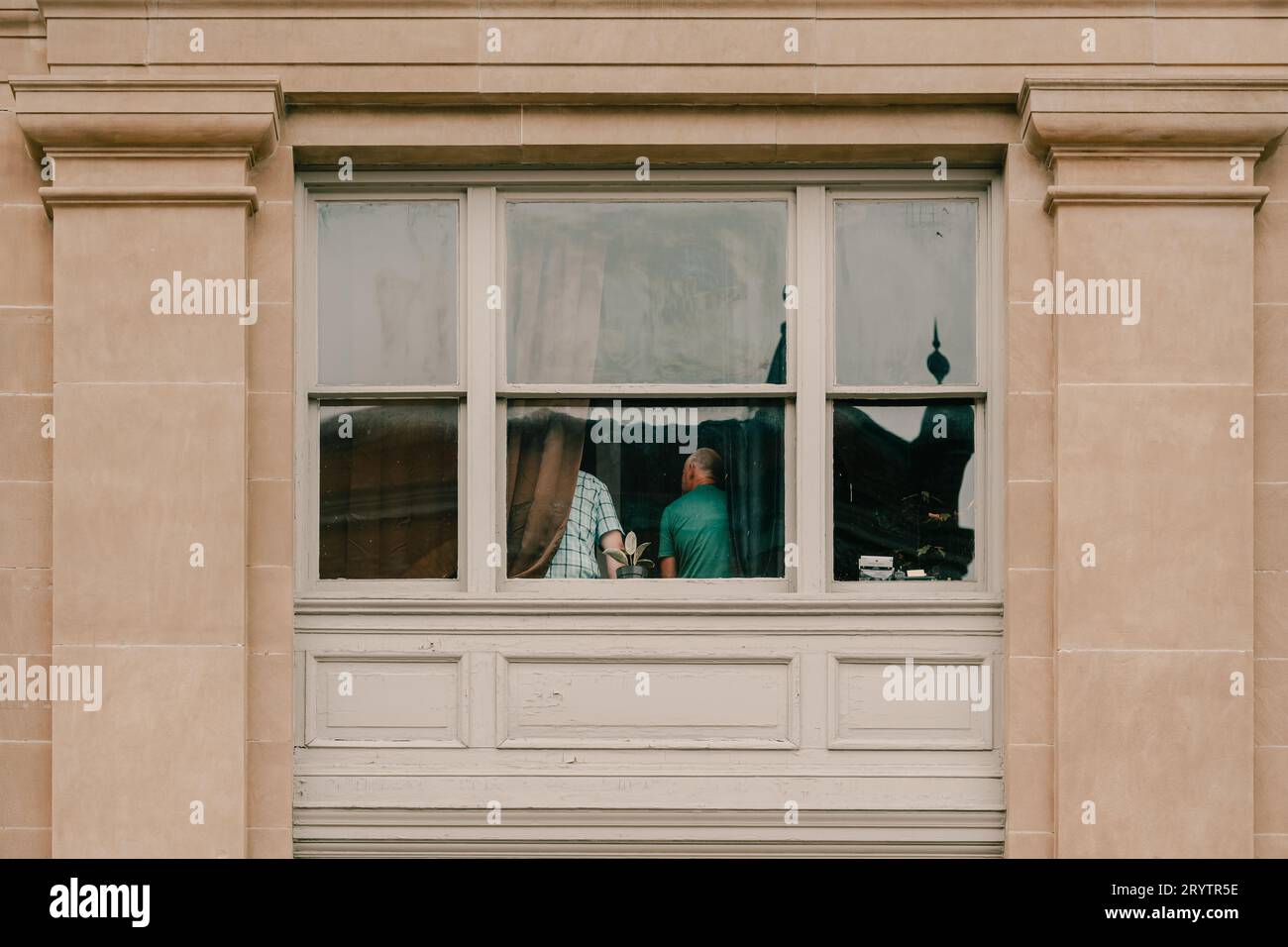The people standing in front of a window inside a building Stock Photo ...
