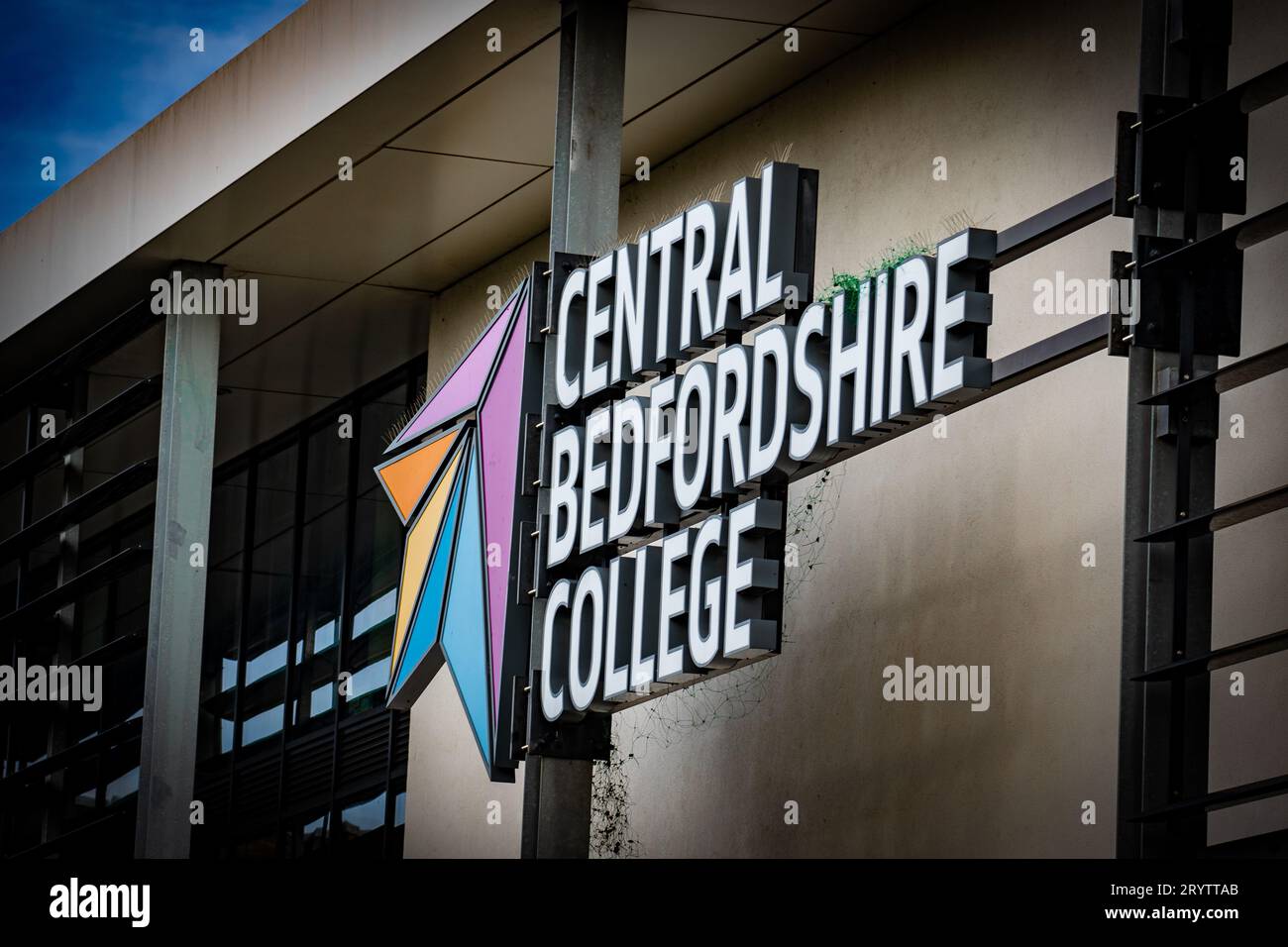 A sign indicating a college campus building, featuring text and ...