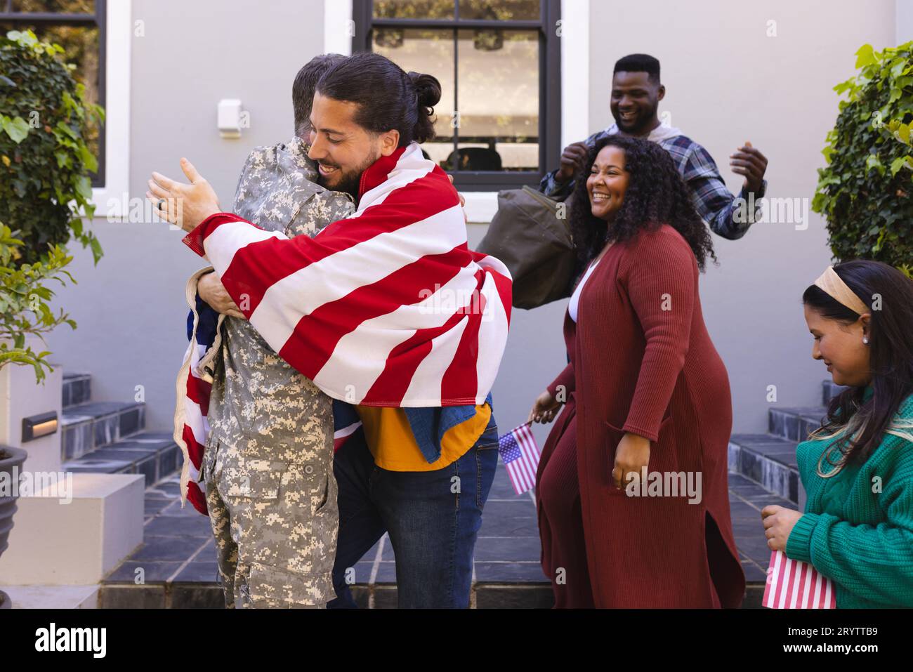 Happy diverse friends with flags welcoming home male soldier friend ...