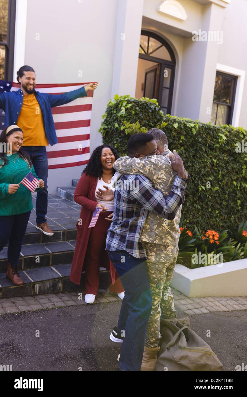 Happy diverse friends with flags welcoming home male soldier friend ...