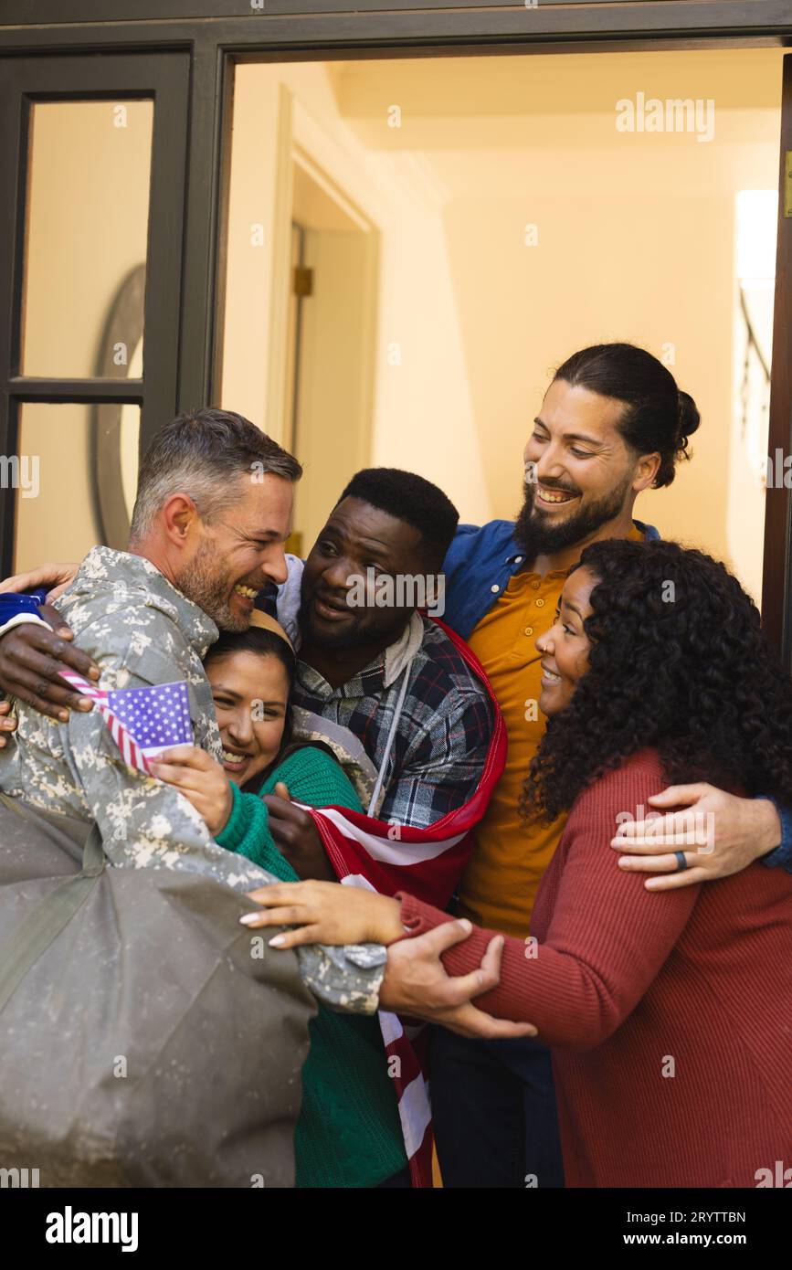 Happy diverse friends with flags welcoming home male soldier friend ...