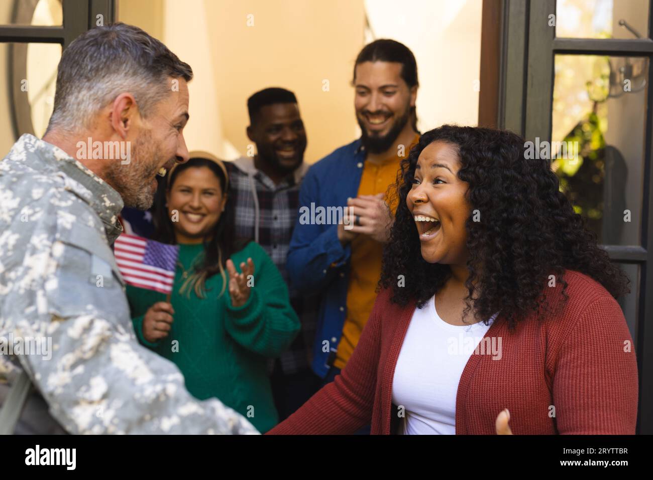 Happy diverse friends with flags welcoming home male soldier friend ...