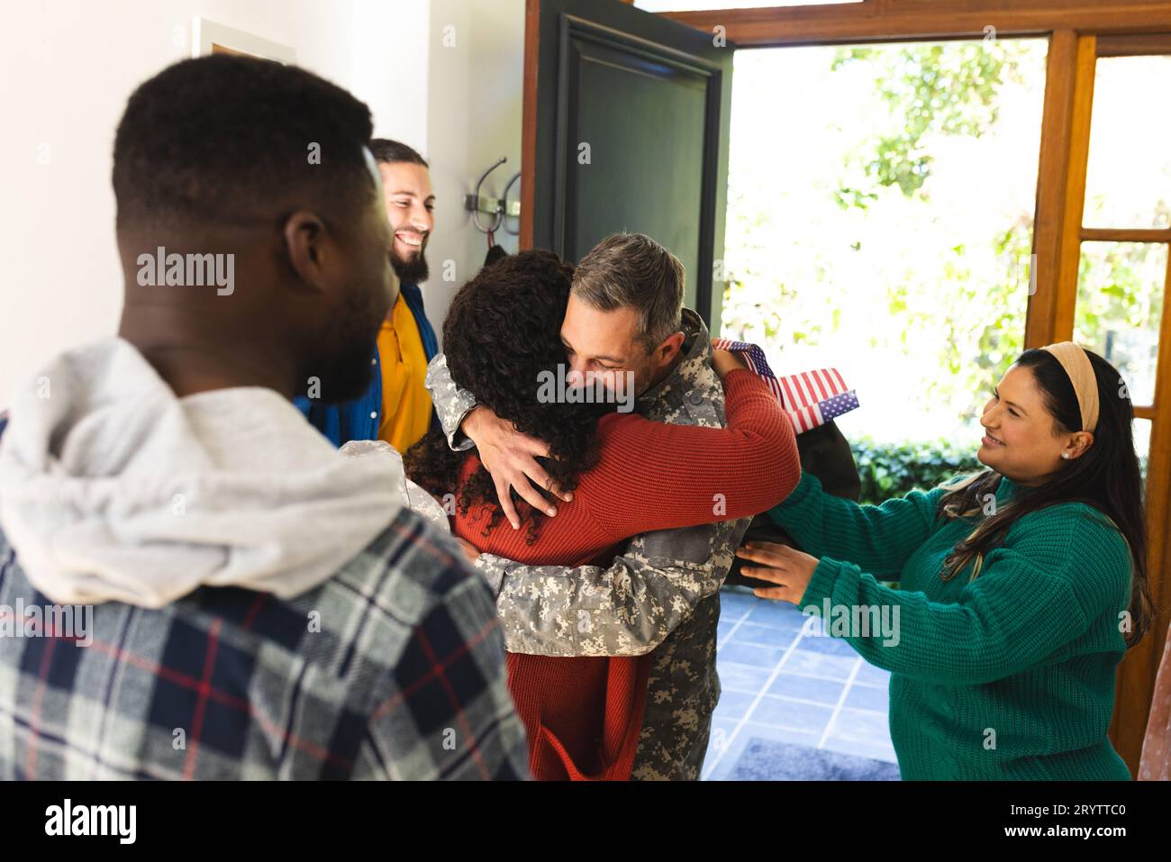 Happy diverse friends with flags welcoming home male soldier friend ...