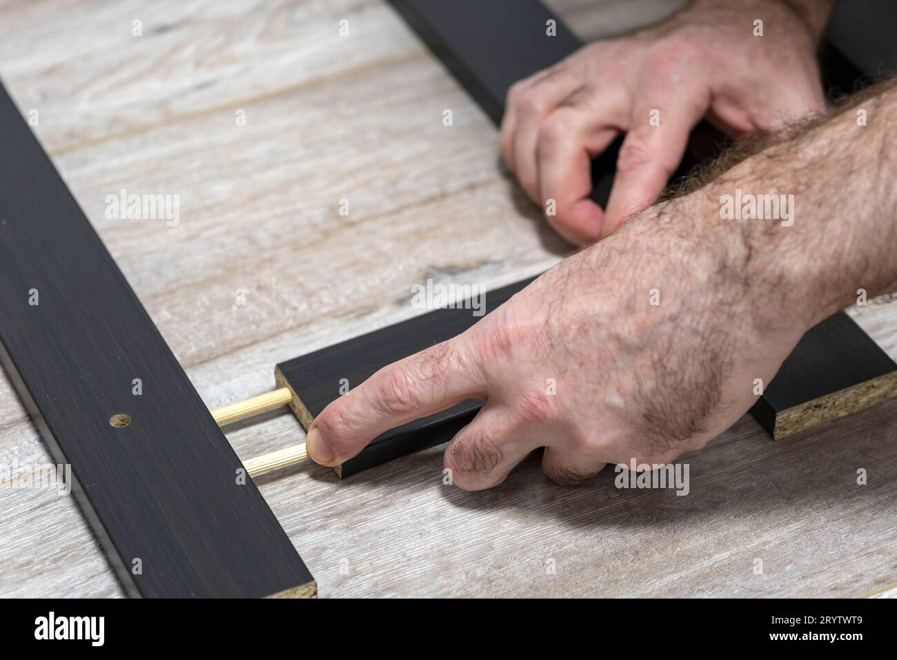 Hands and wooden structures. Joining pieces of furniture. Installation ...
