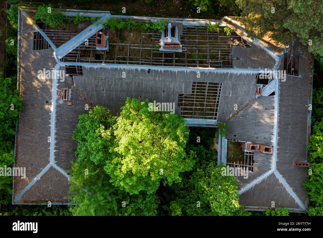 Aerial view of the leaky roof of an abandoned decaying building in a ...