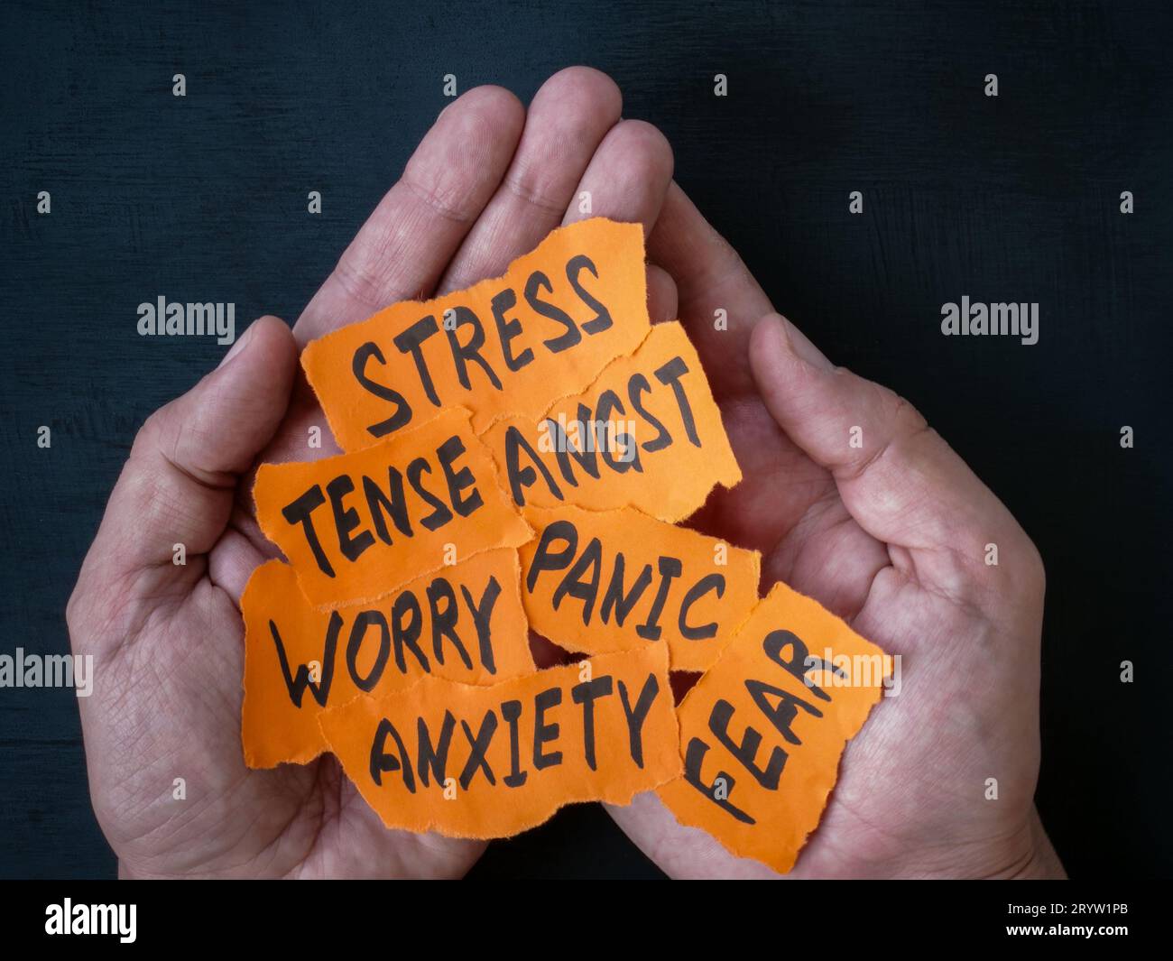 Hands hold pieces of paper with words worry, stress panic and anxiety ...