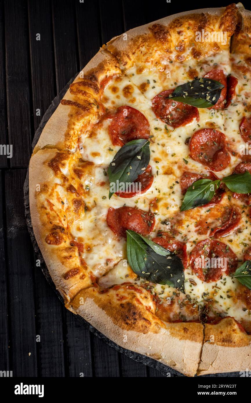 A close-up image of a freshly-baked pizza, featuring a golden-brown ...