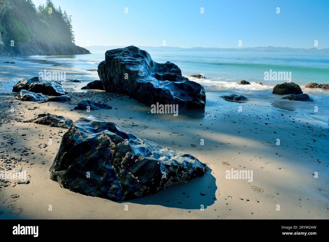 A scenic beach with rocky terrain and seaweed scattered Stock Photo - Alamy