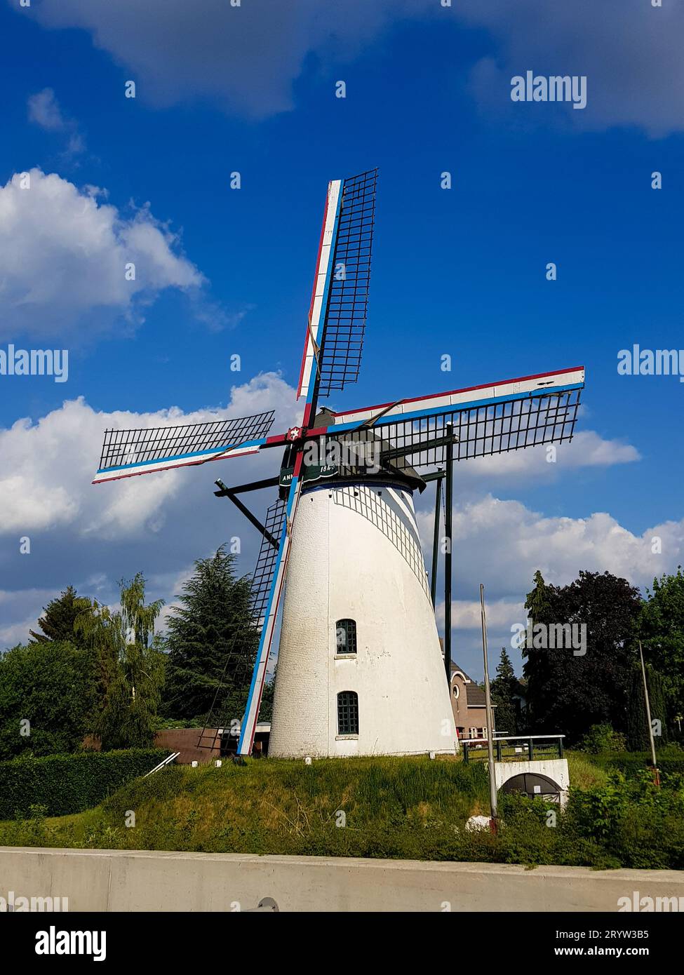 A traditional windmill situated in a scenic outdoor setting, with lush ...