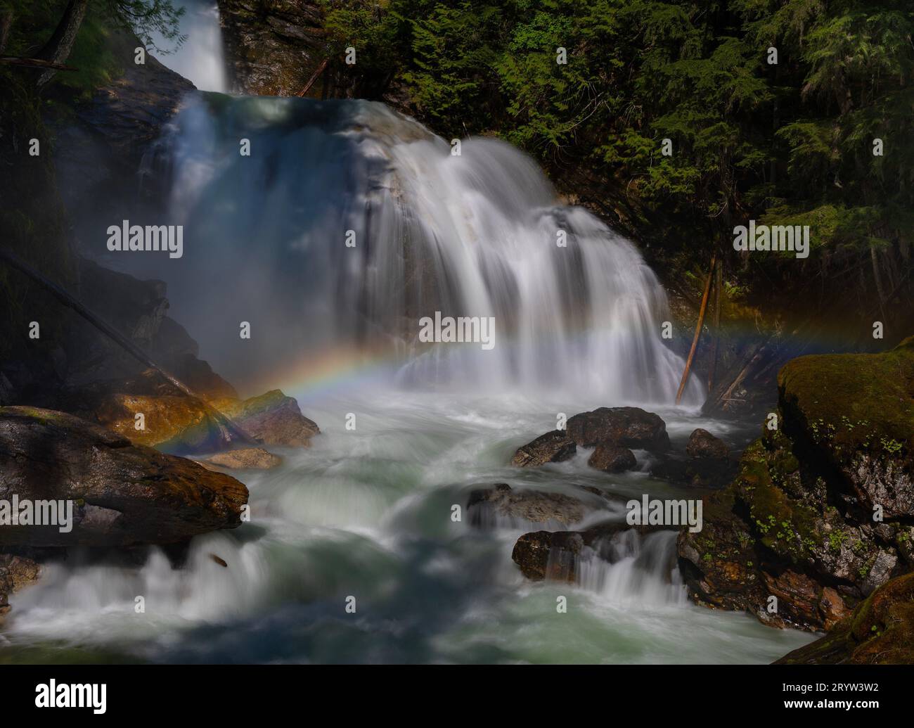 The vibrant Crazy Creek waterfalls cascading over a rocky cliff side in ...