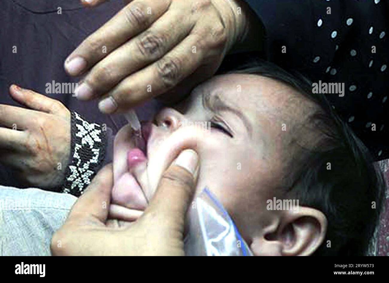 Health worker administrates polio-vaccine drops to a child during anti ...