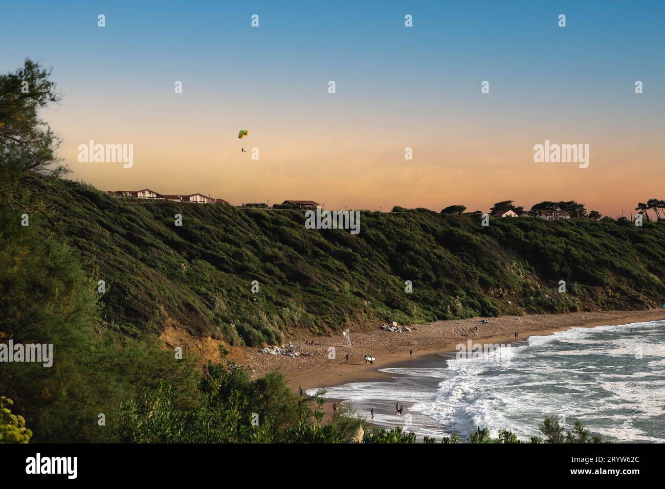 A scenic beach landscape featuring a shoreline of large, jagged rocks ...