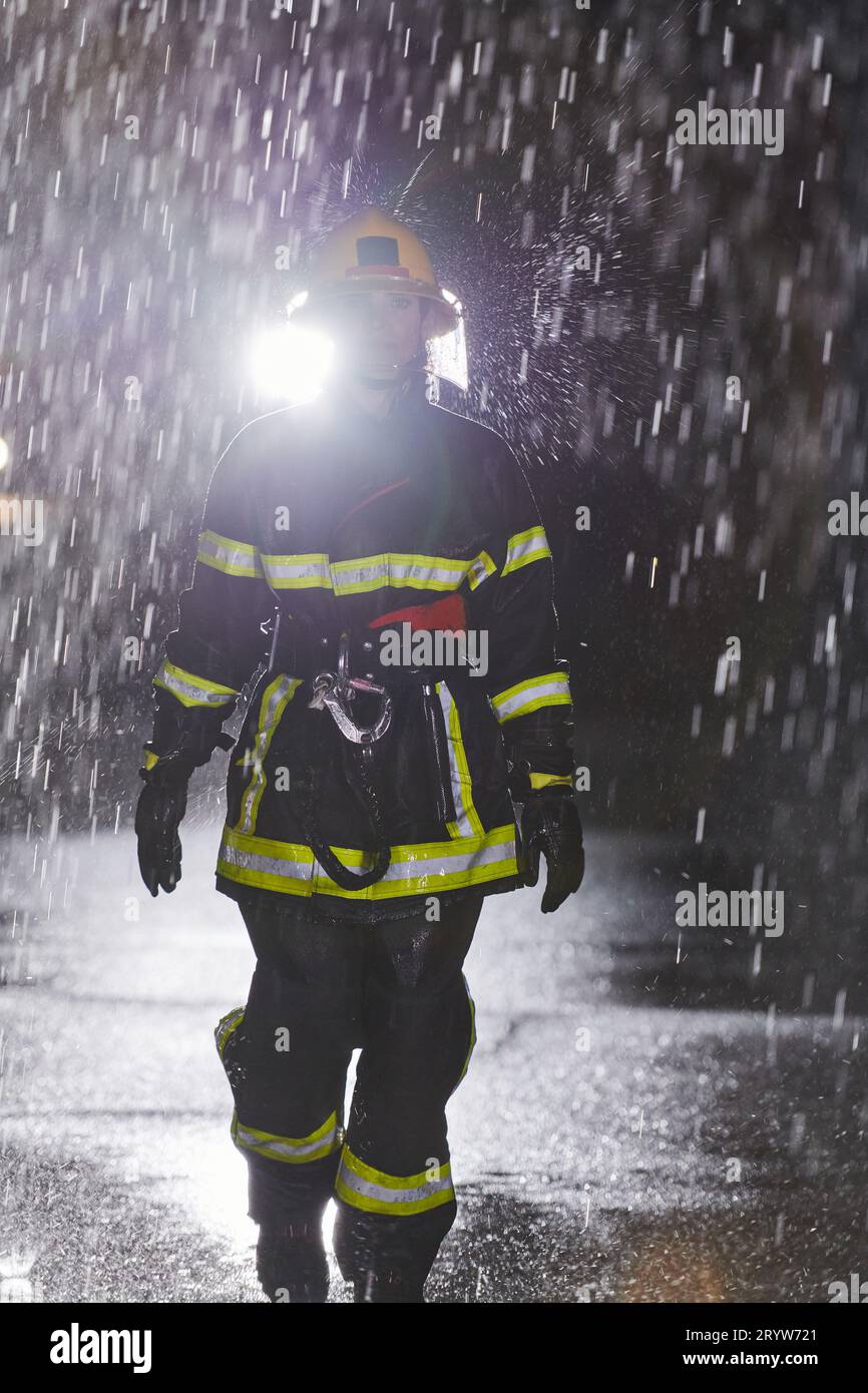 A determined female firefighter in a professional uniform striding ...