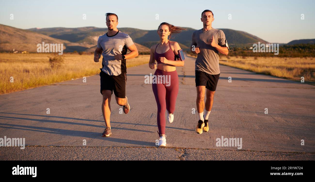 A group of young athletes running together in the early morning light ...