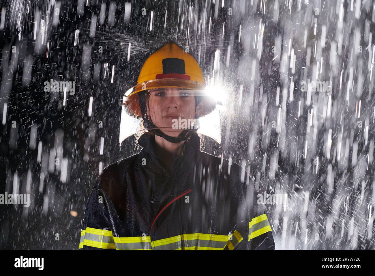 A determined female firefighter in a professional uniform striding ...