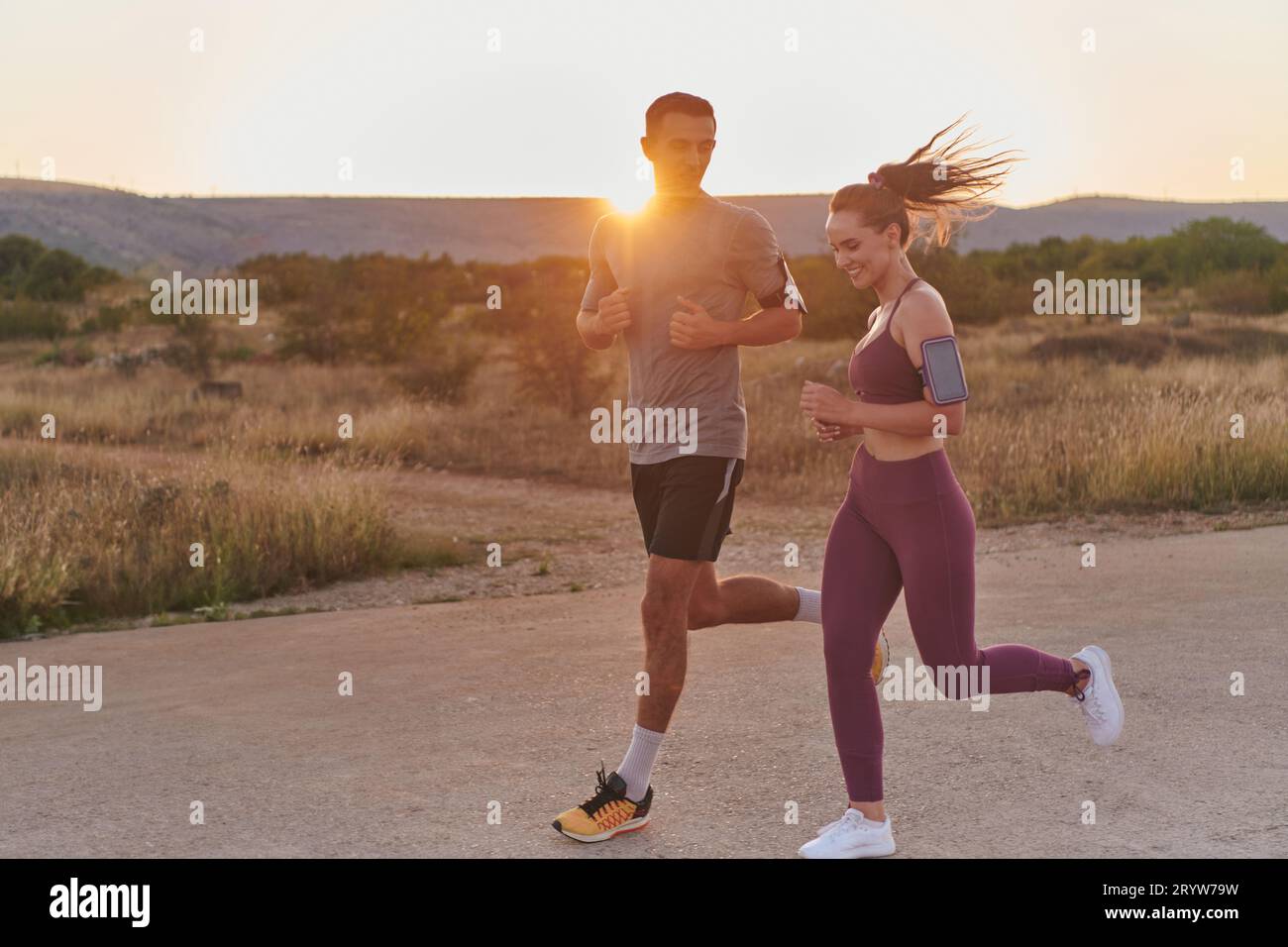 A handsome young couple running together during the early morning hours ...