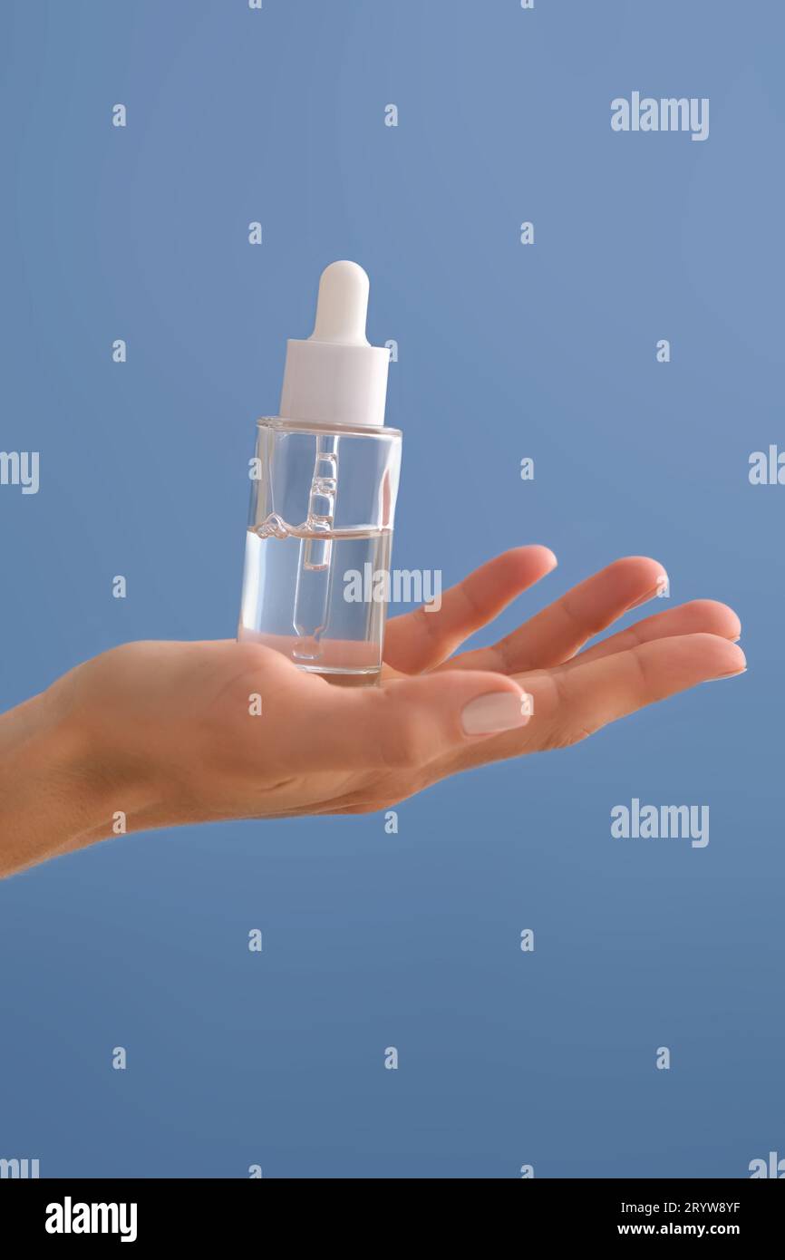Serum with a pipette in female hands on a blue background Stock Photo ...