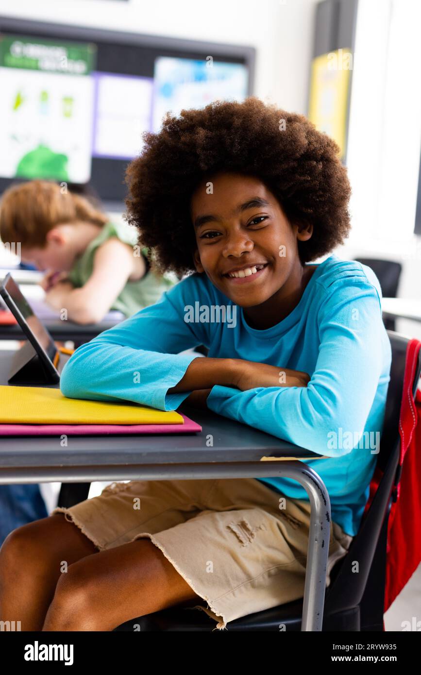 Happy diverse schoolchildren sitting at desks in school classroom Stock ...