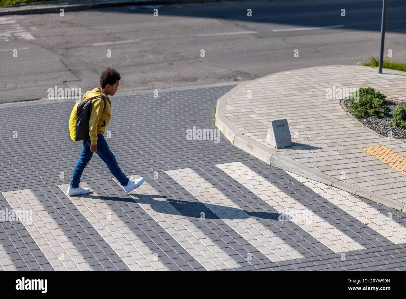 Schoolboy with backpack on his back crossing the street Stock Photo - Alamy