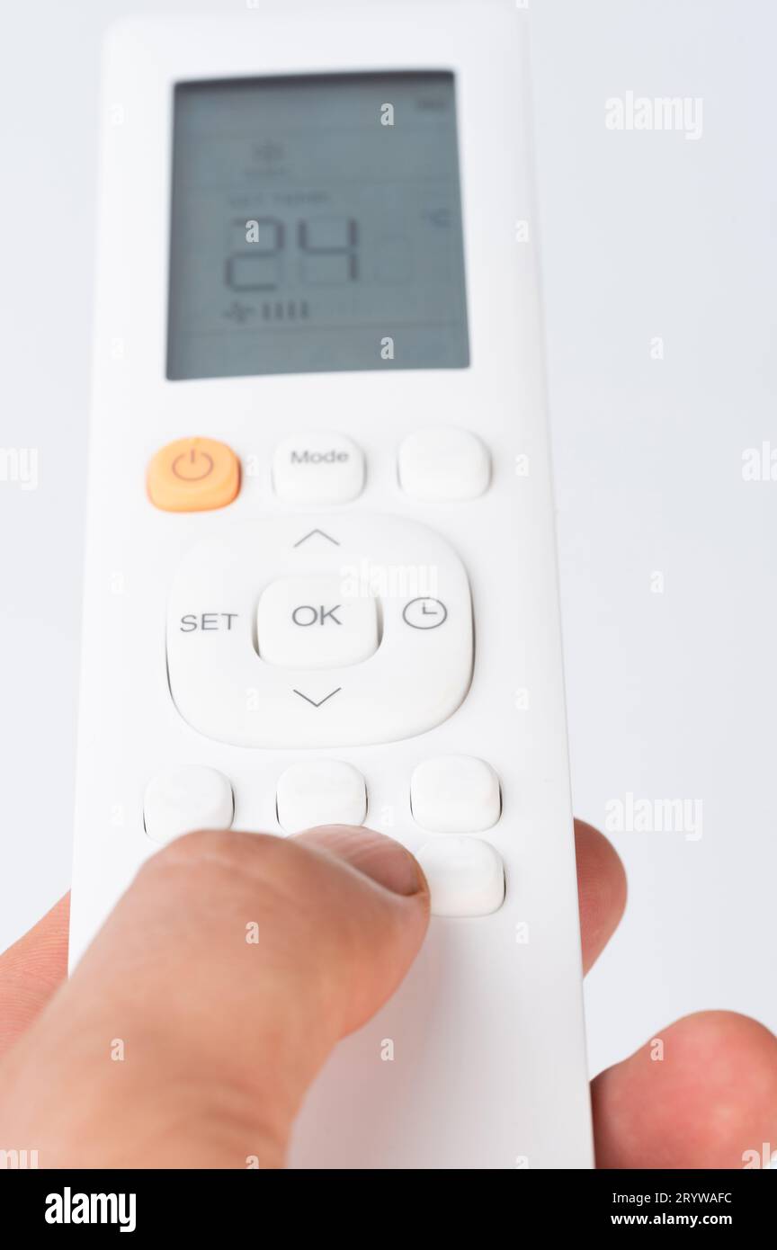 Switch setting of air conditioner on remote control in hand isolated ...