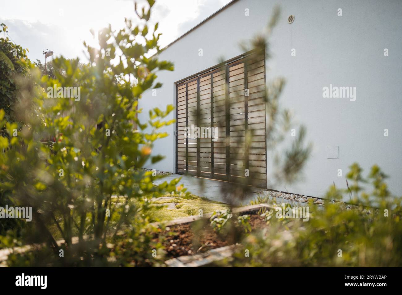 Modern house with beautiful garden and wooden gate, side outdoor view ...