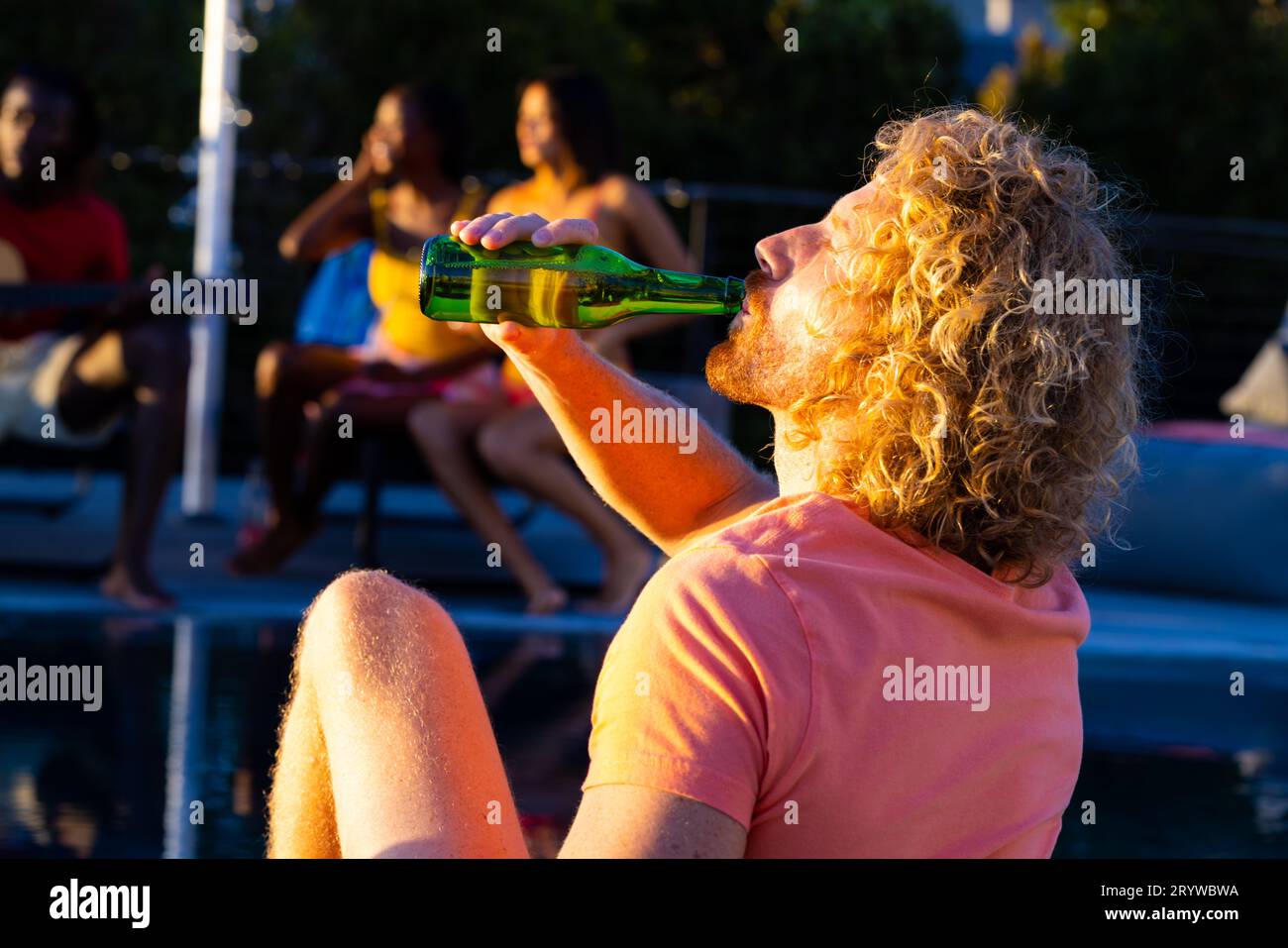 Happy diverse group of friends having pool party and drinking beer in ...