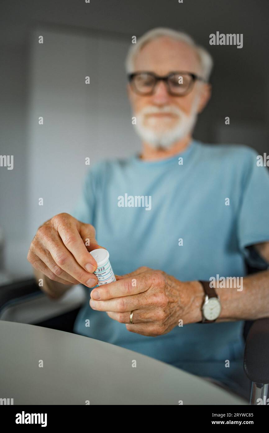 Senior man reading the usage instructions on a pill bottle label Stock ...