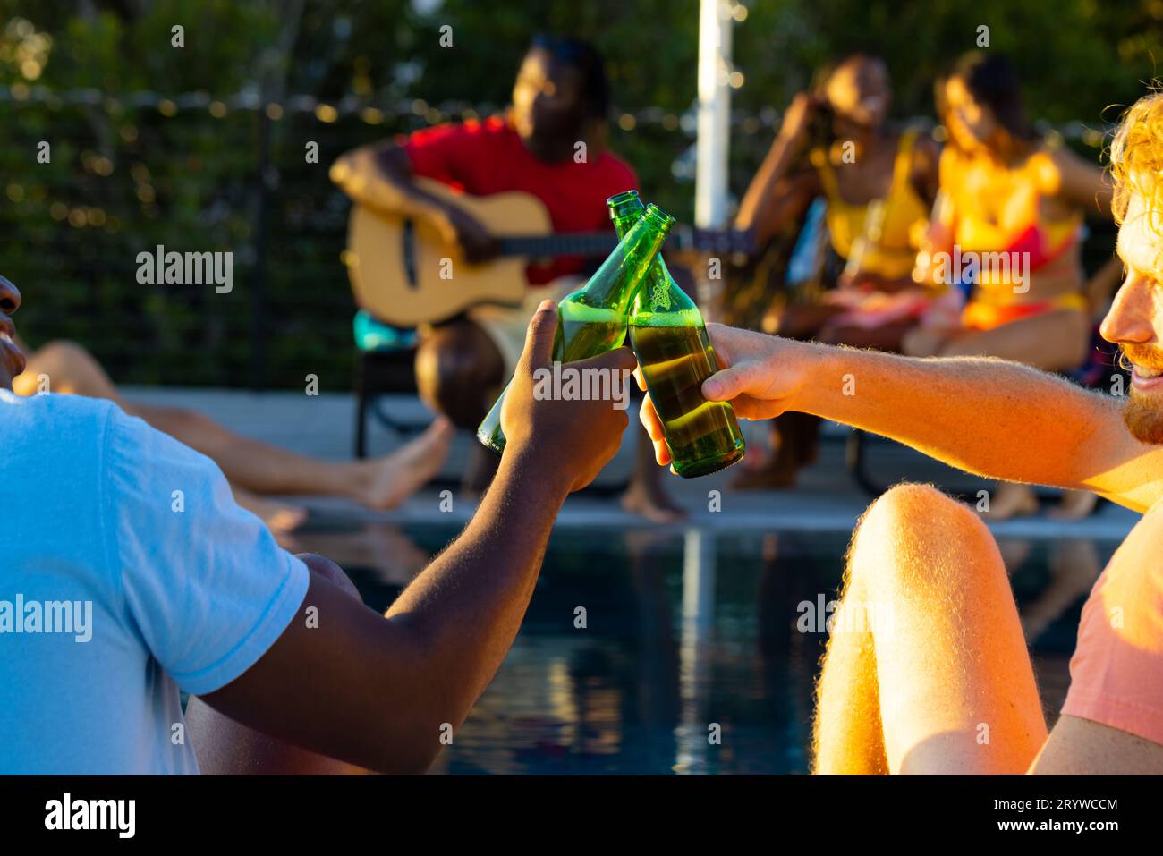 Happy diverse group of friends having pool party, drinking beer and ...