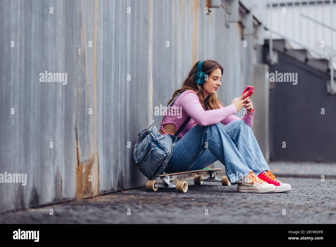 Portrait of generation z girl student sitting outdoors in the city ...
