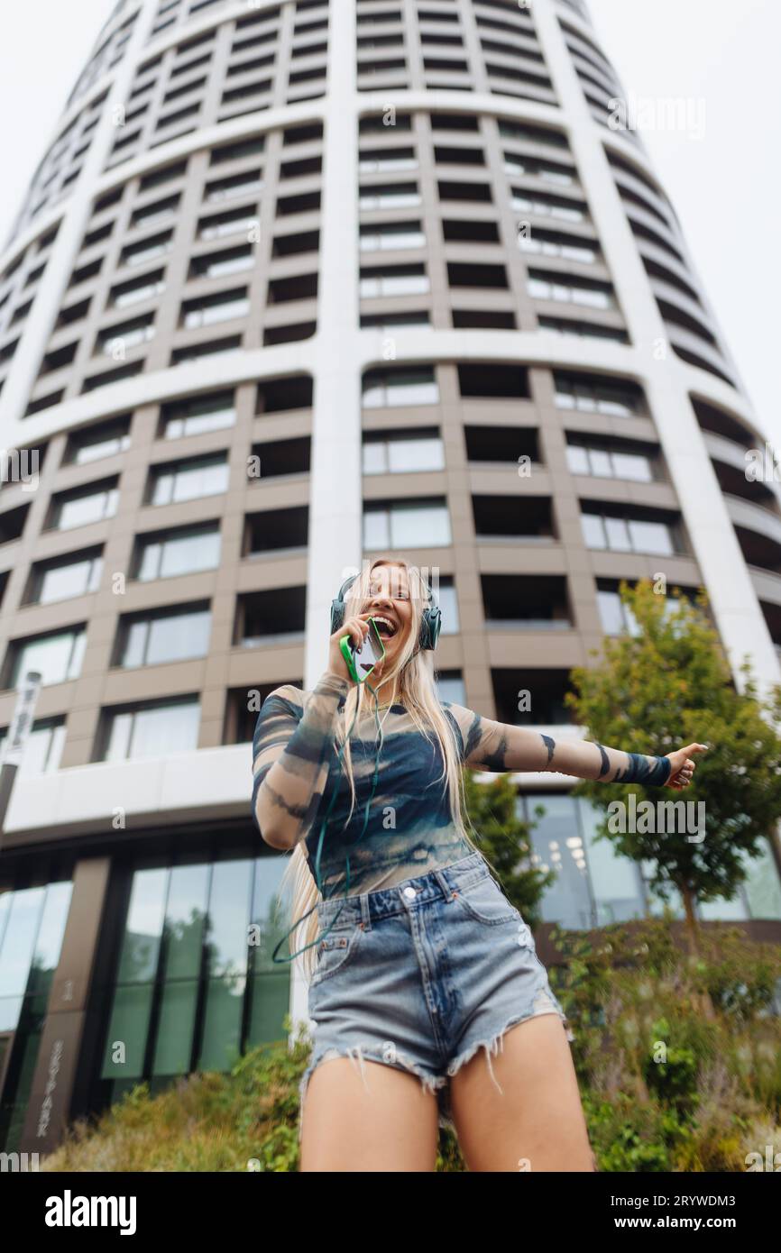 Portrait of stylish generation z girl student outdoors in the city ...