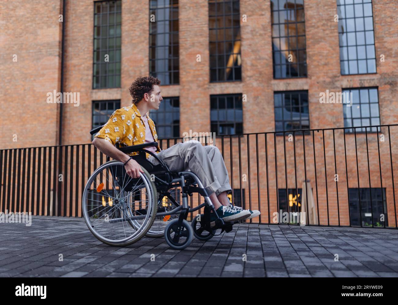 Gen Z boy in a wheelchair in the city Stock Photo - Alamy