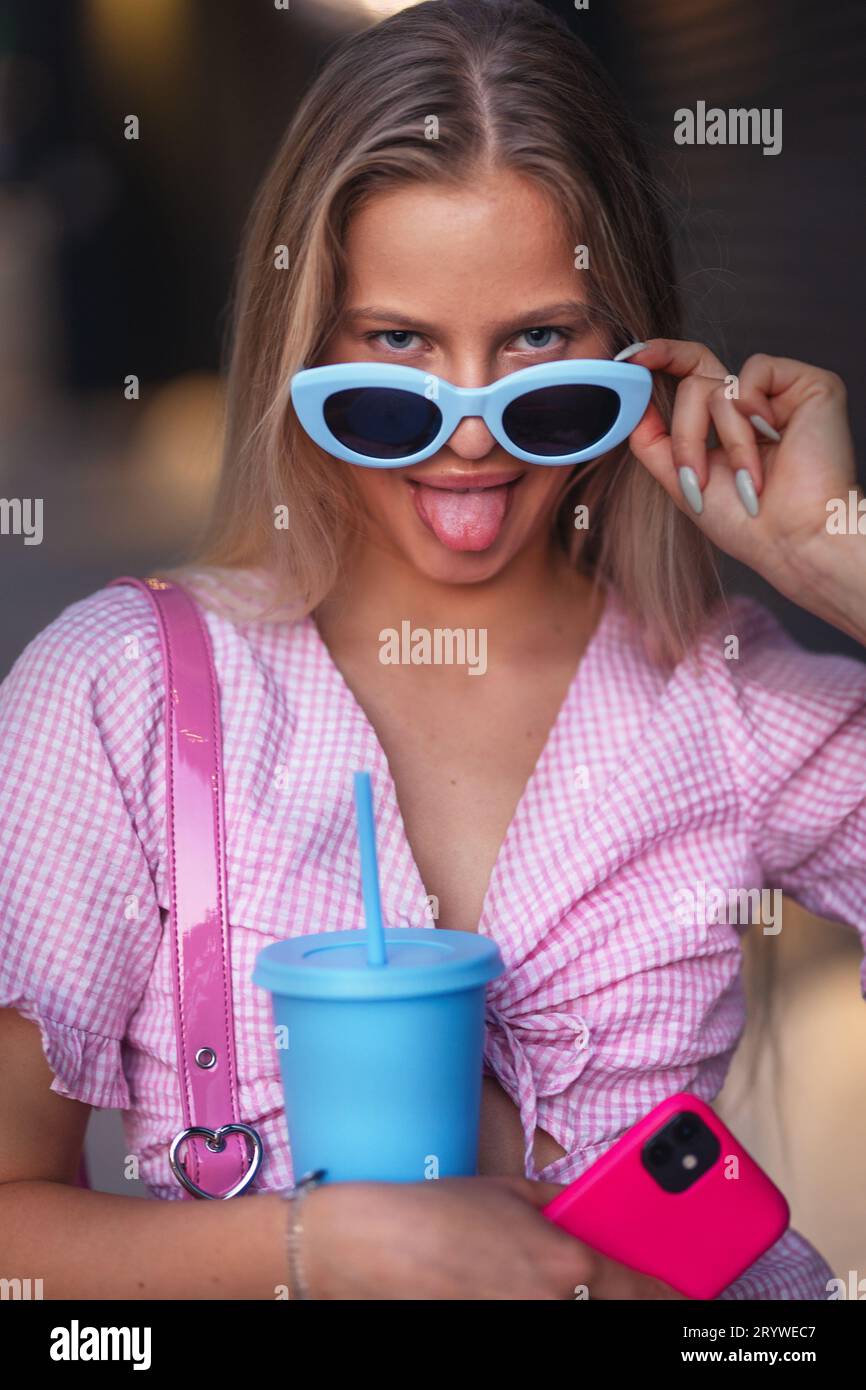 Portrait of gen Z girl in pink outfit before going the cinema to watch ...