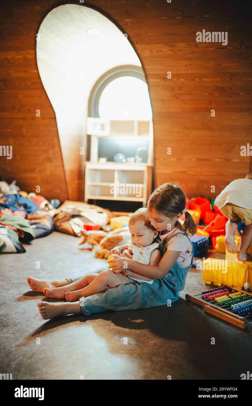 Older sister taking care of little baby Stock Photo - Alamy