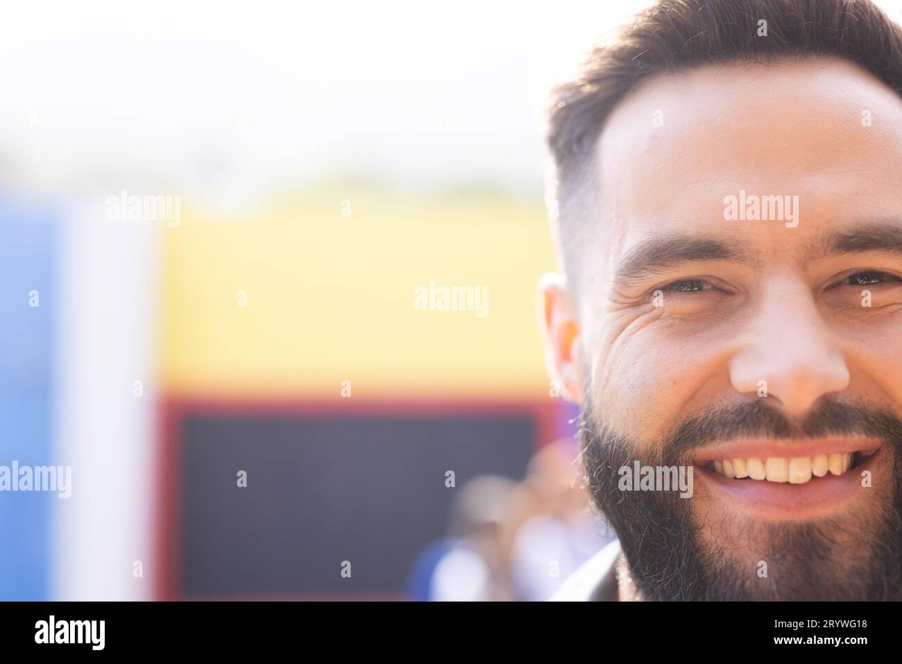 Portrait of smiling, bearded caucasian male school teacher outdoors ...