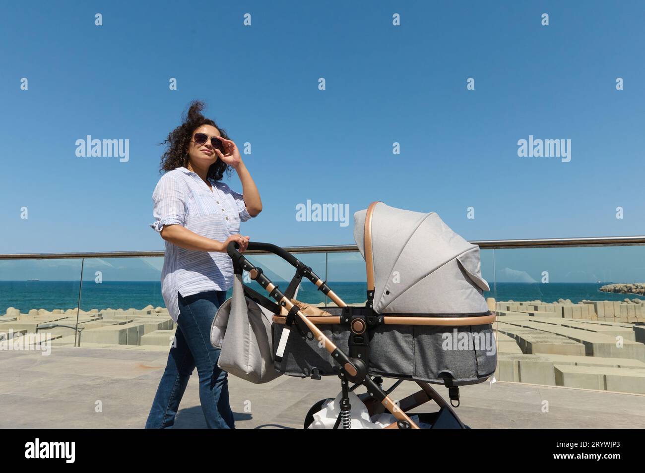 Beautiful woman wearing sunglasses, enjoying a promenade along Atlantic ...
