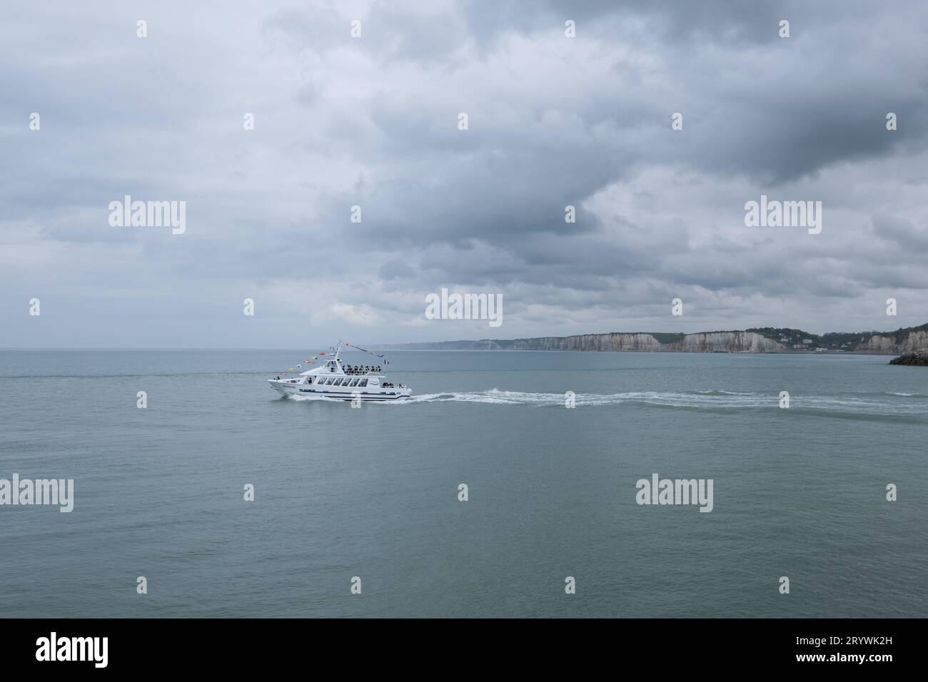 A large boat sailing across a tranquil lake with snow-capped mountain ...