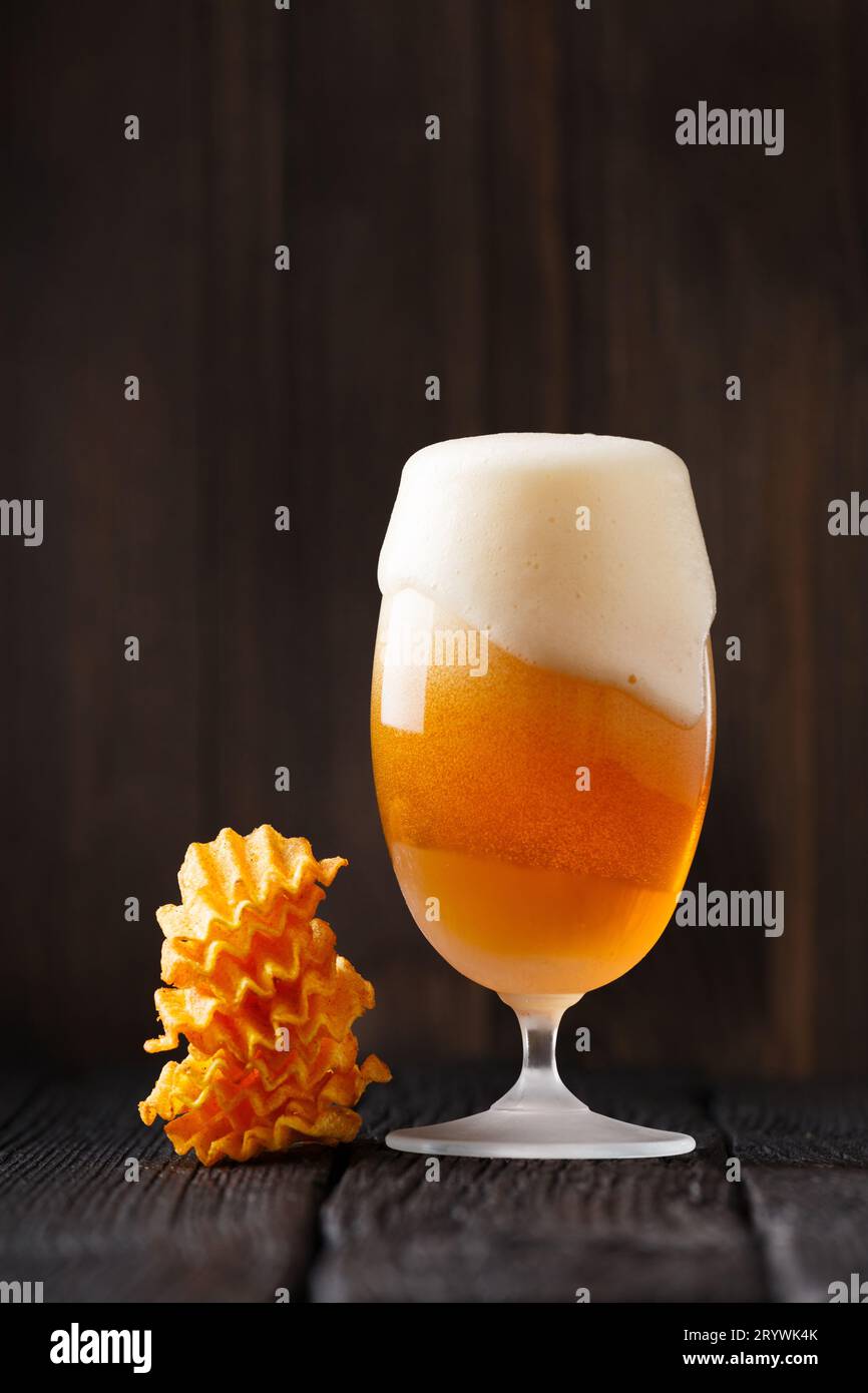 Beer in a glass mug with beautiful thick foam, the foam is pouring, a ...