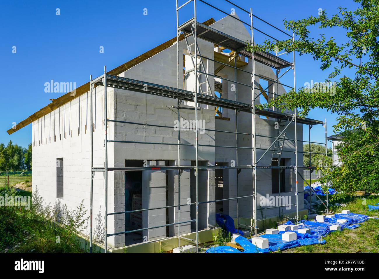 Unfinished residential house with white block walls and a wooden beam ...