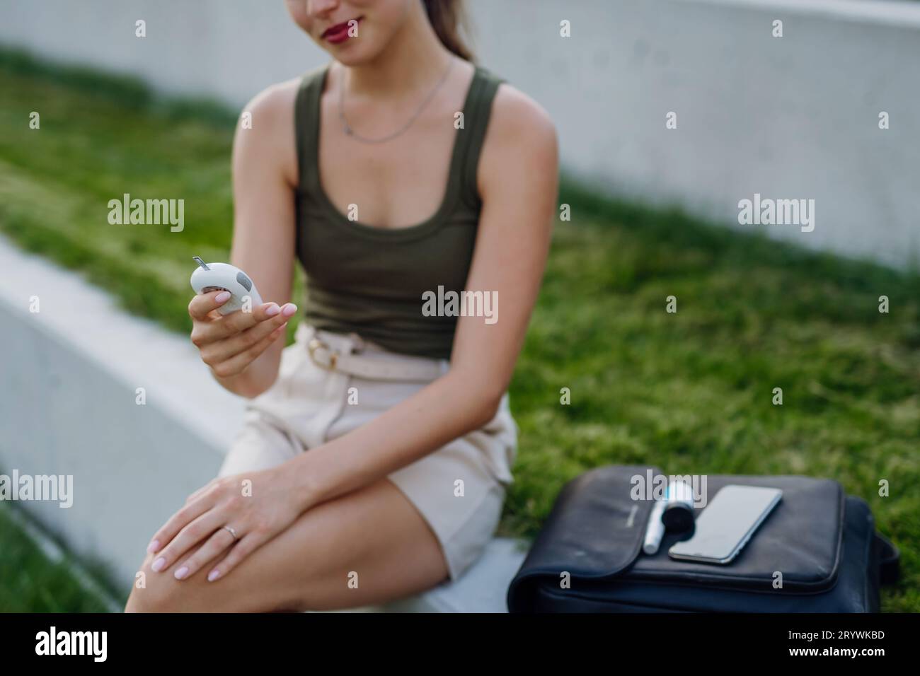 Diabetic woman checking her blood glucose level using a fingerstick ...