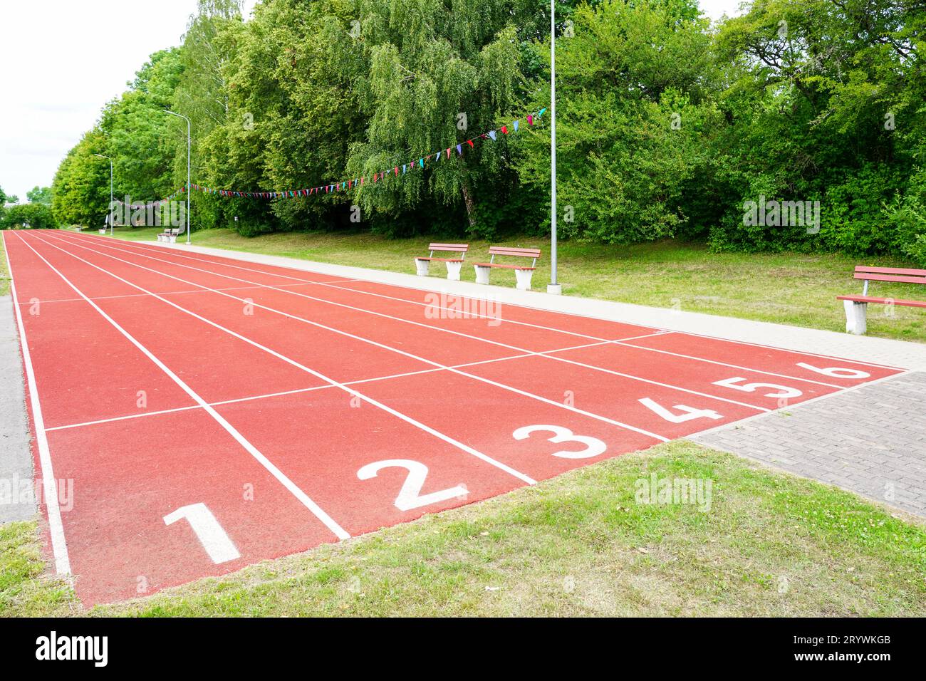 A school stadium running track with a red surface and six numbered ...